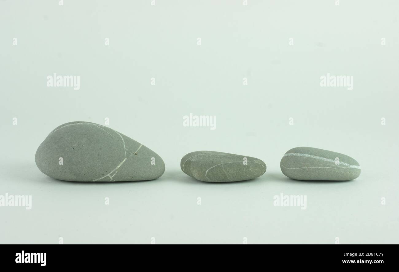 Three grey rocks in a line Stock Photo - Alamy
