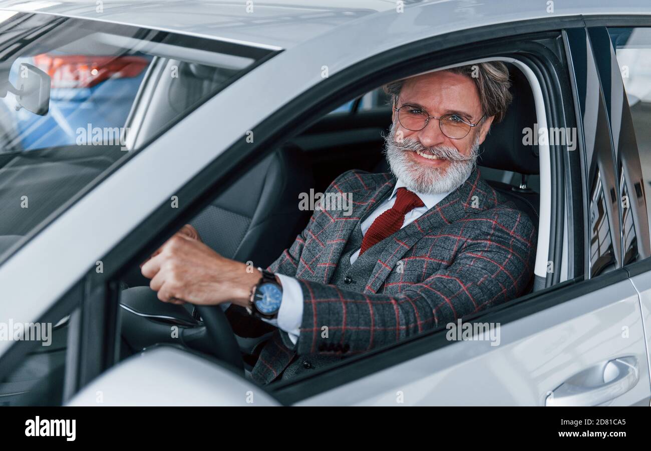 Happy stylish senior man with grey hair and mustache is in the modern ...