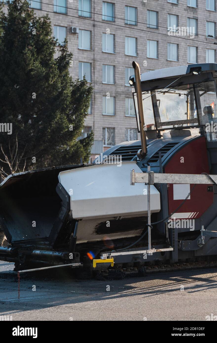 Industrial asphalt paver machine laying fresh asphalt on road ...