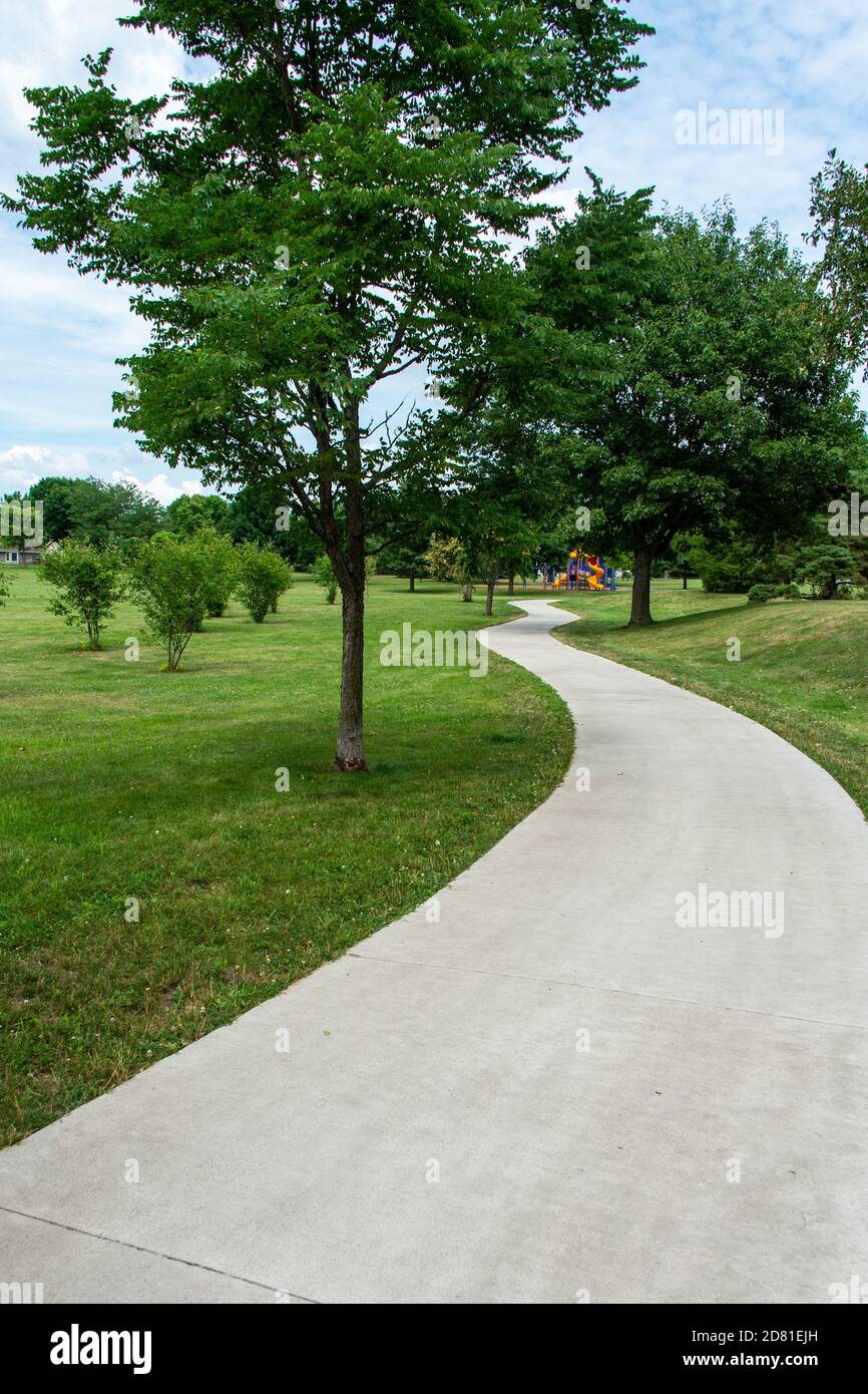 A park path leads to a distant playground set Stock Photo - Alamy
