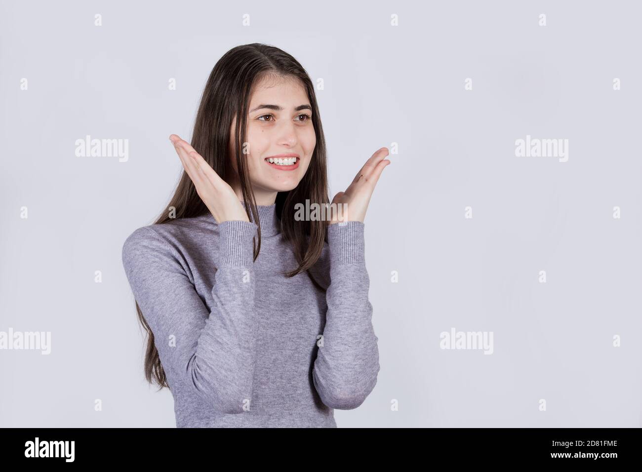 Young girl positively surprised with hands on her cheek. Beautiful ...