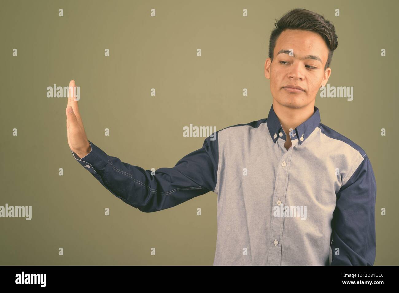 Young handsome Indian man looking smart against colored background ...