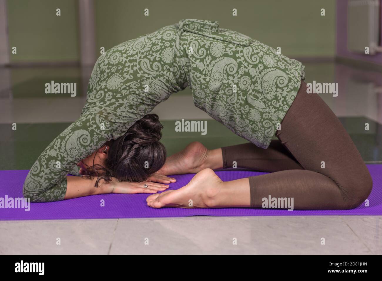Yoga trainee works yoga exercises Stock Photo - Alamy