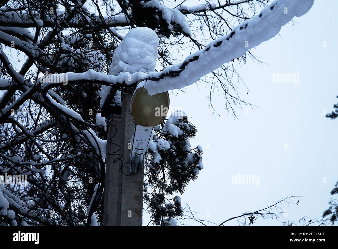 The electric cable is covered with frozen snow and frost after sleet ...