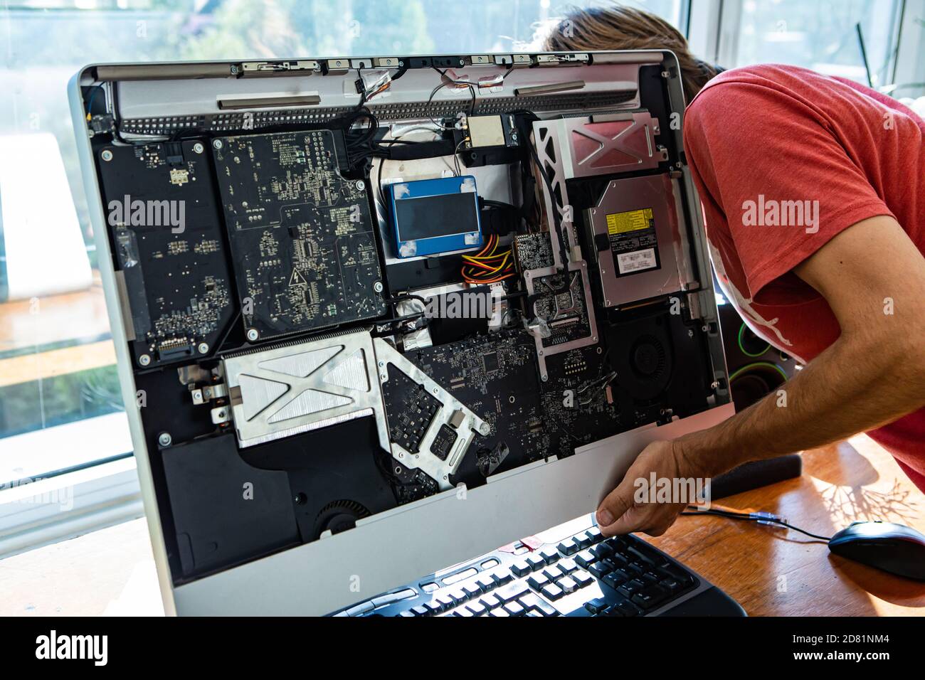 Male computer technician repairing broken silver desktop computer while ...