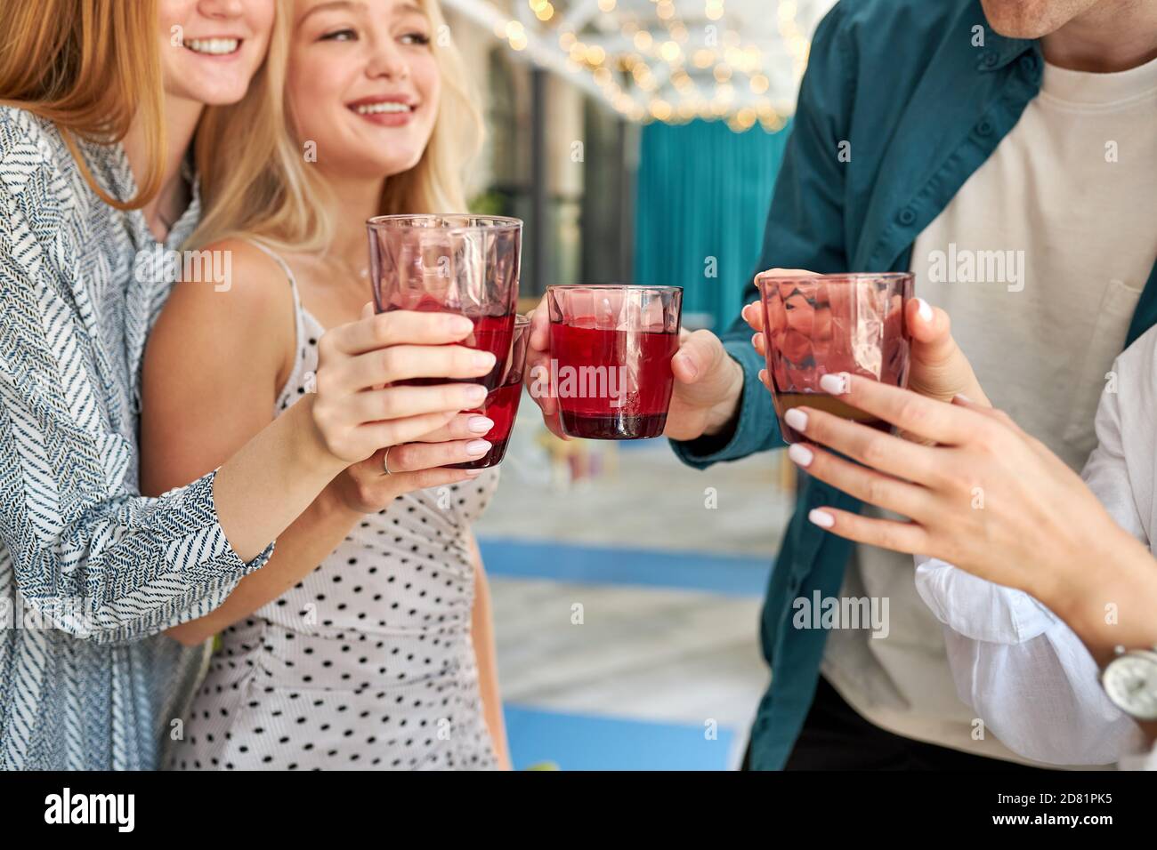 group of happy friends celebrating in cafe, they clink glasses with ...