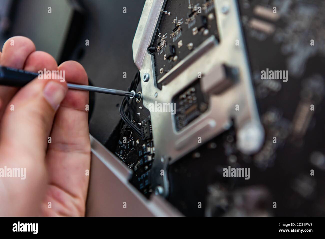 Selective focus of computer technician hands holding screwdriver tool ...