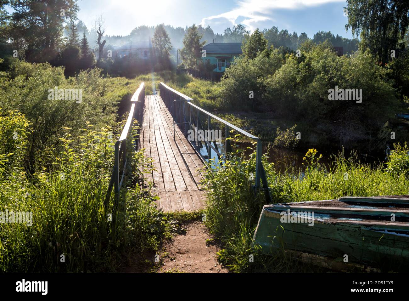 A bridge across a small river in the village in the sun rays Stock ...