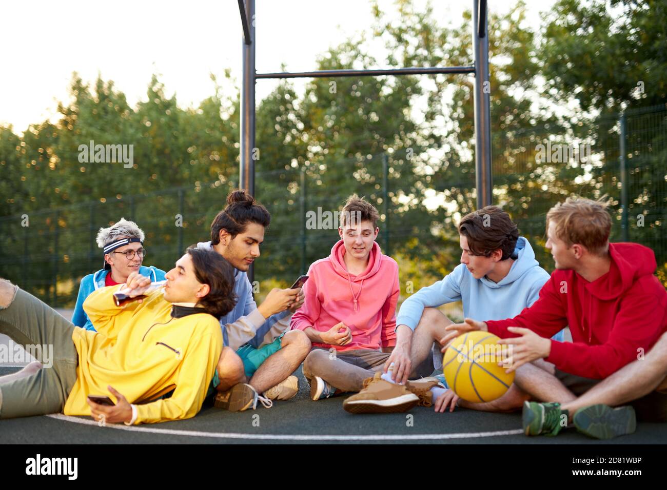 young basketball players take a break after game, have fun and talk. in ...