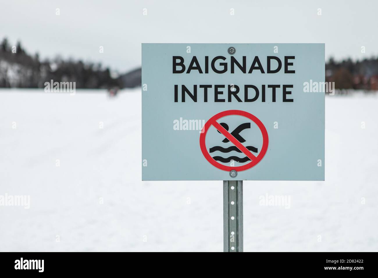 Board on pole with text of baignade interdite written in french ...