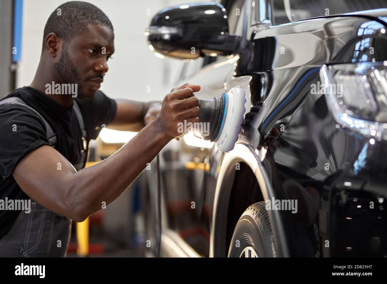 hard-working auto mechanic worker polishing car at automobile repair ...