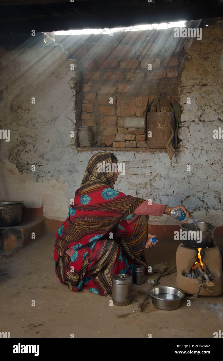 Woman cooking dinner on an outdoor wood fire stove in India Stock Photo ...