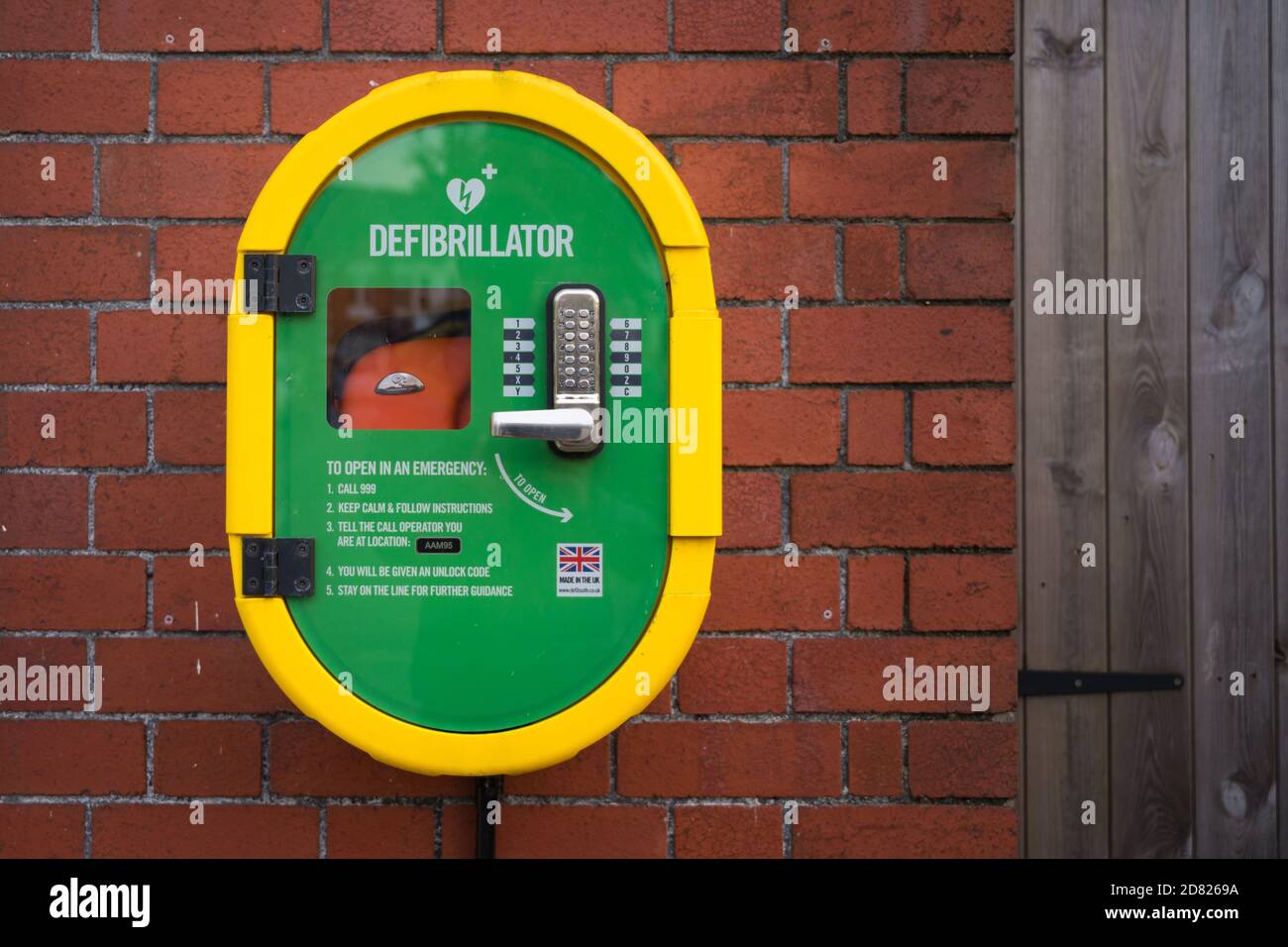 A defibrillator attached to a brick wall in the UK Stock Photo - Alamy