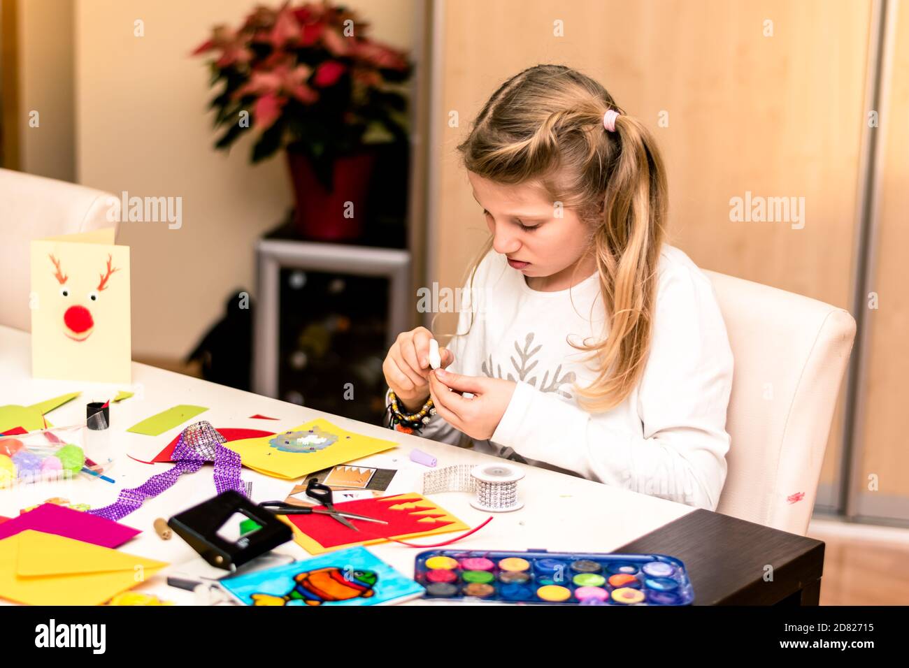 adorable blond girl making christmas card for friends and relatives ...