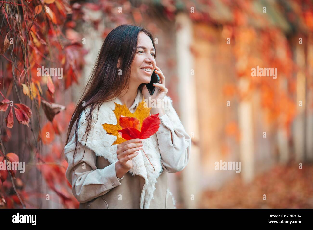 Beautiful woman in autumn park under fall foliage Stock Photo - Alamy