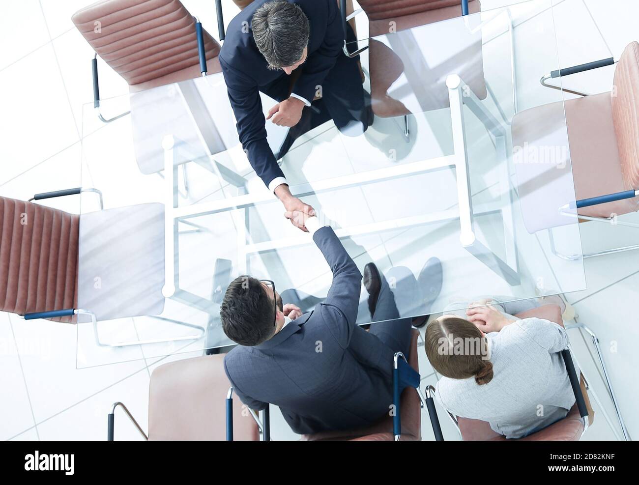 Handshake across table hi-res stock photography and images - Alamy