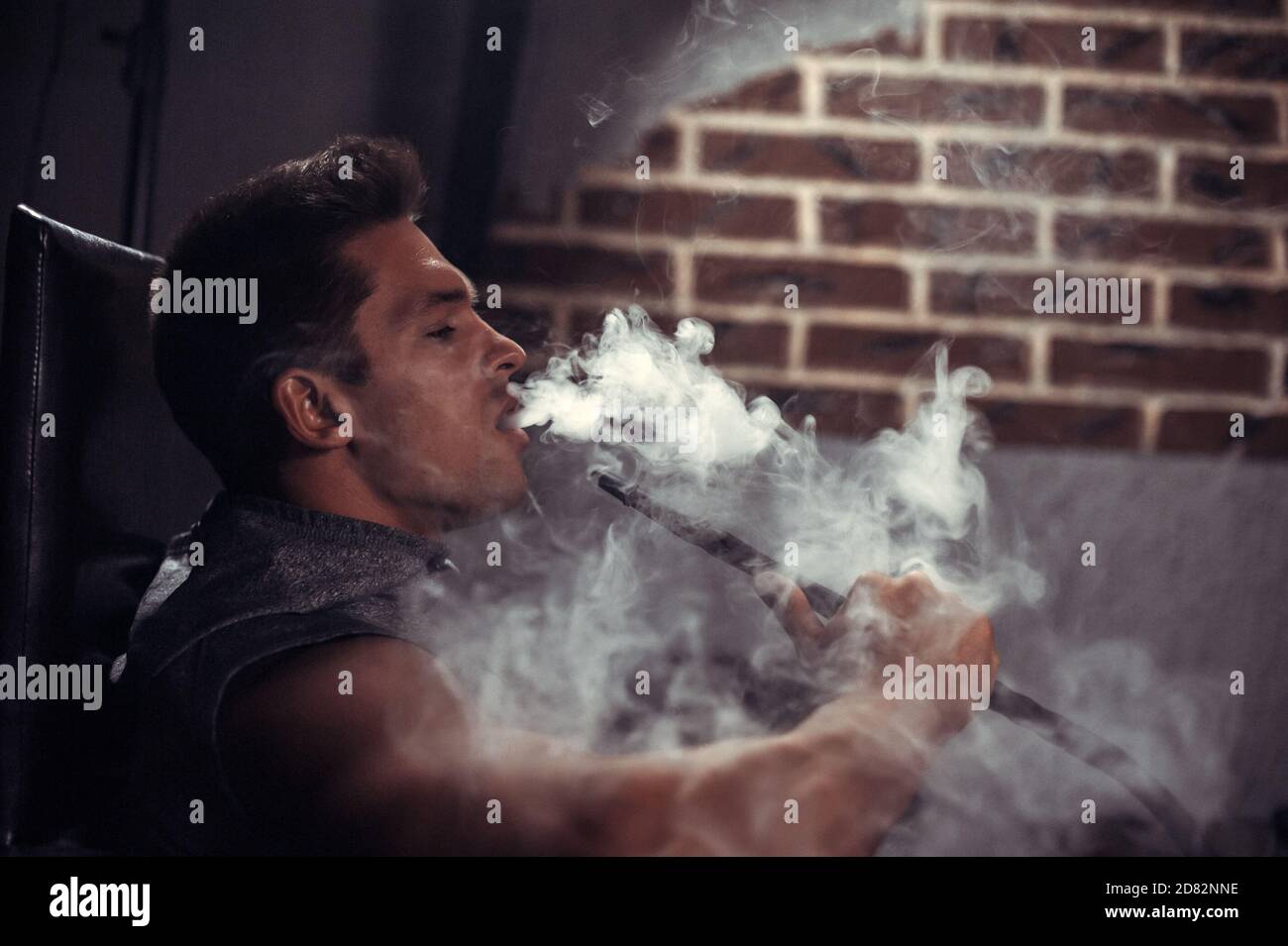 Young handsome guy enjoying a hookah at arabic restaurant Stock Photo ...