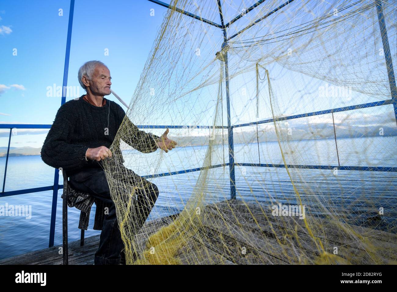 Senior fisherman holding fishing net near the beach. Fisherman hands ...