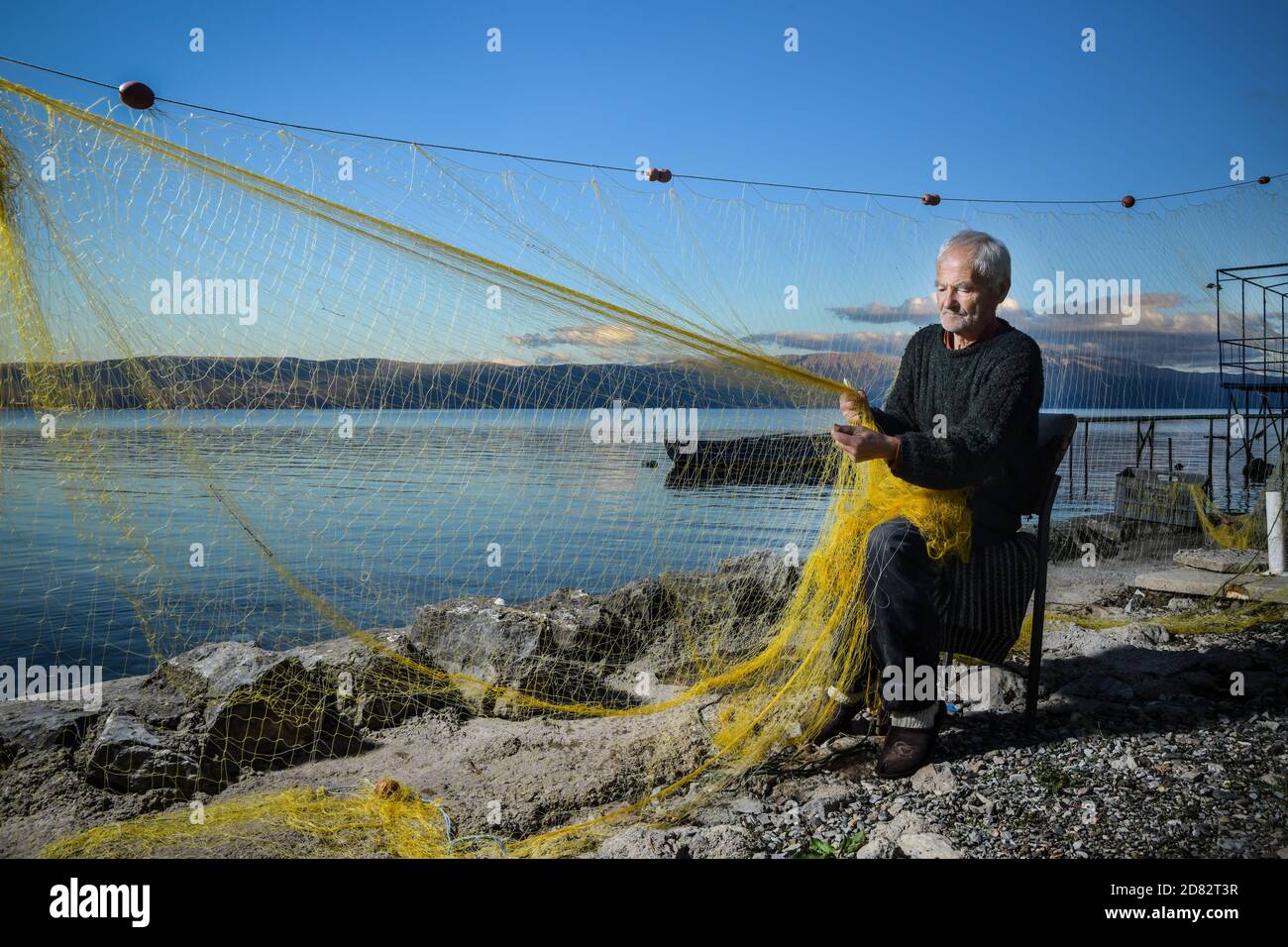 Senior fisherman holding fishing net near the beach. Fisherman hands ...