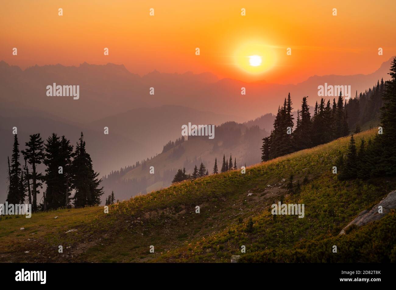 Colorful orange sunset going down in the cascade mountains Stock Photo ...