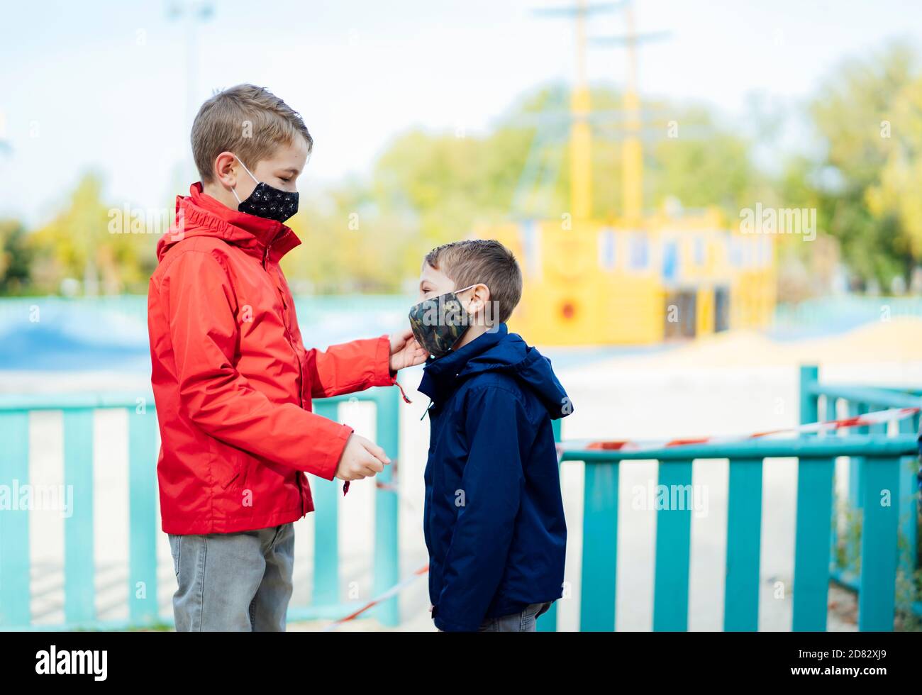 little boy putting the mask on his brother Stock Photo - Alamy