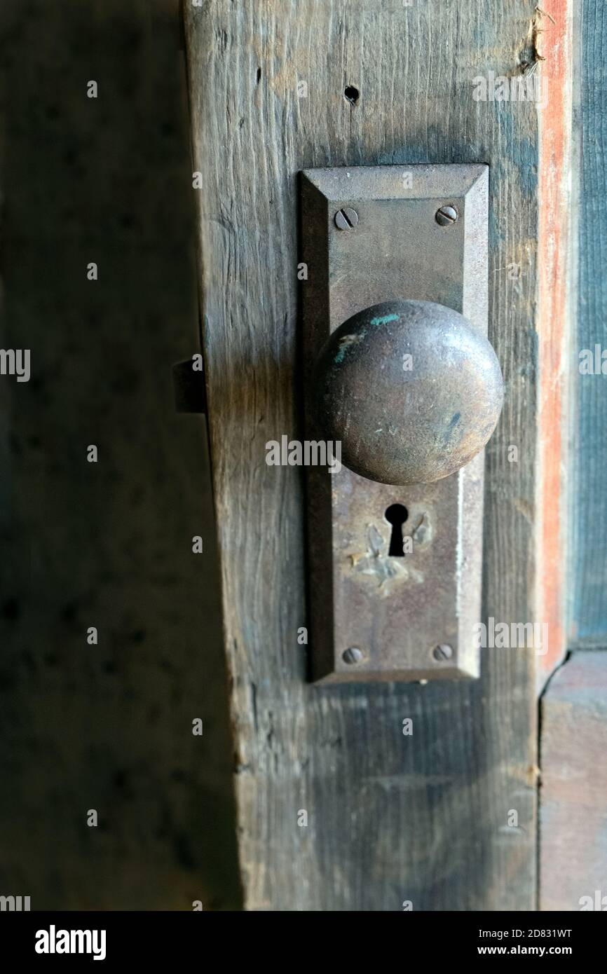close up of an old wood door with vintage knob and plate for a skeleton ...