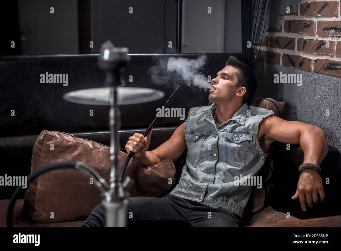 Young fellow relaxes in a hookah in nightclub Stock Photo - Alamy
