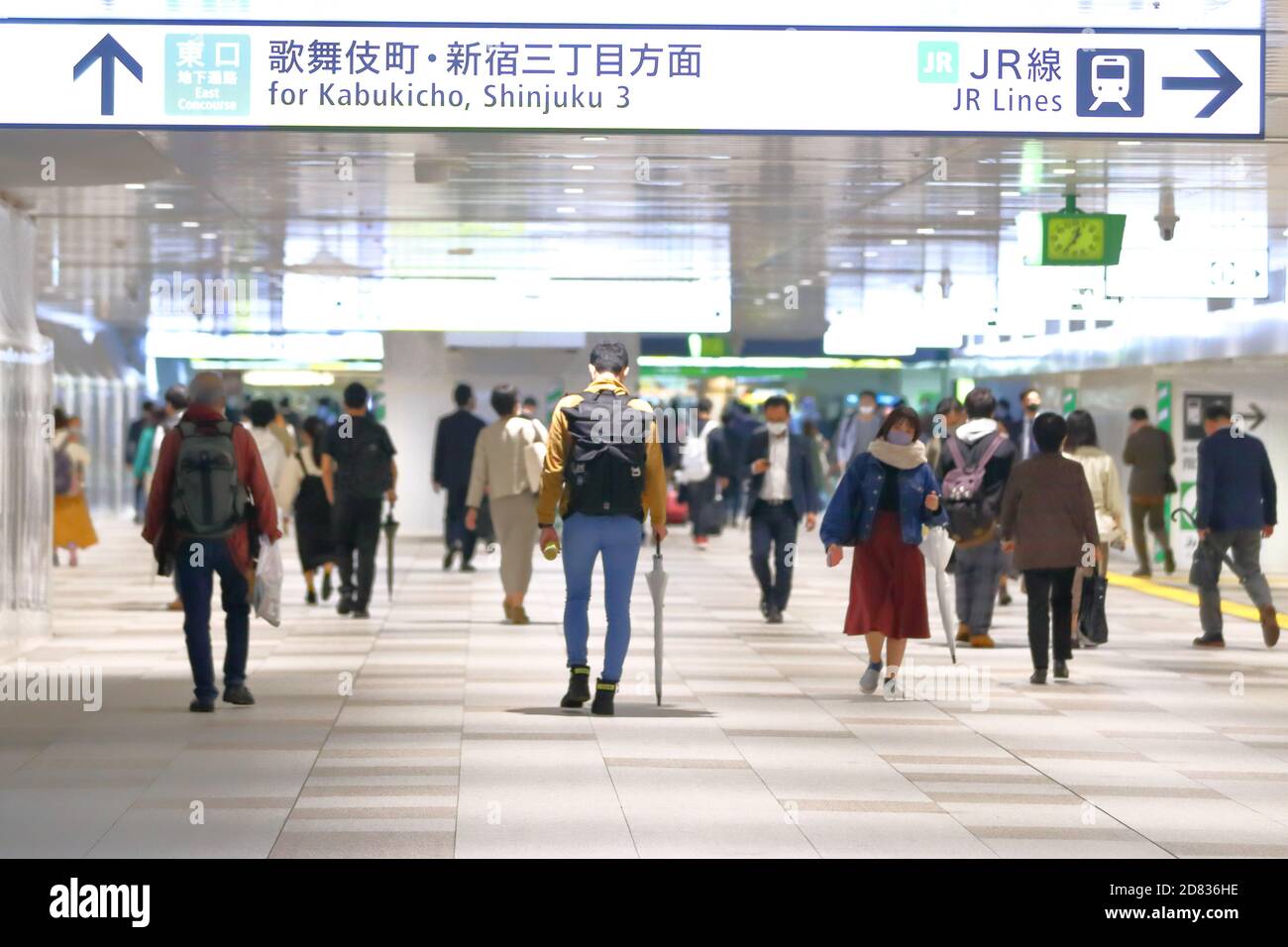 Pedestrians walk an underground walkway at JR Shinjuku Station in Tokyo ...