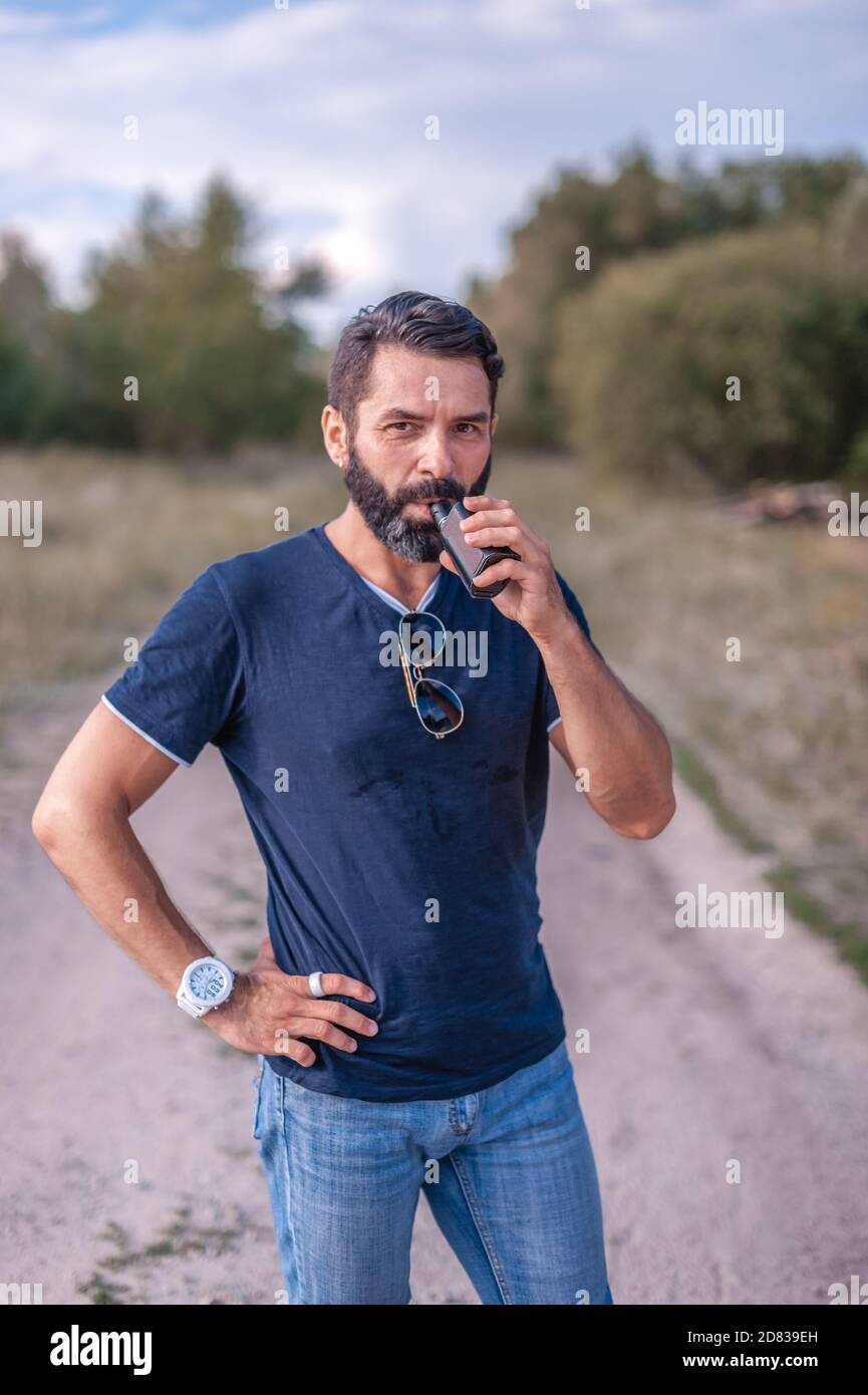 Confident smoker enjoying an vape in the woods. Vaping concept Stock ...