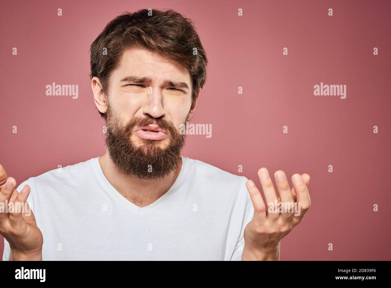 Emotional bearded man in white T-shirt discontent pink background Stock ...