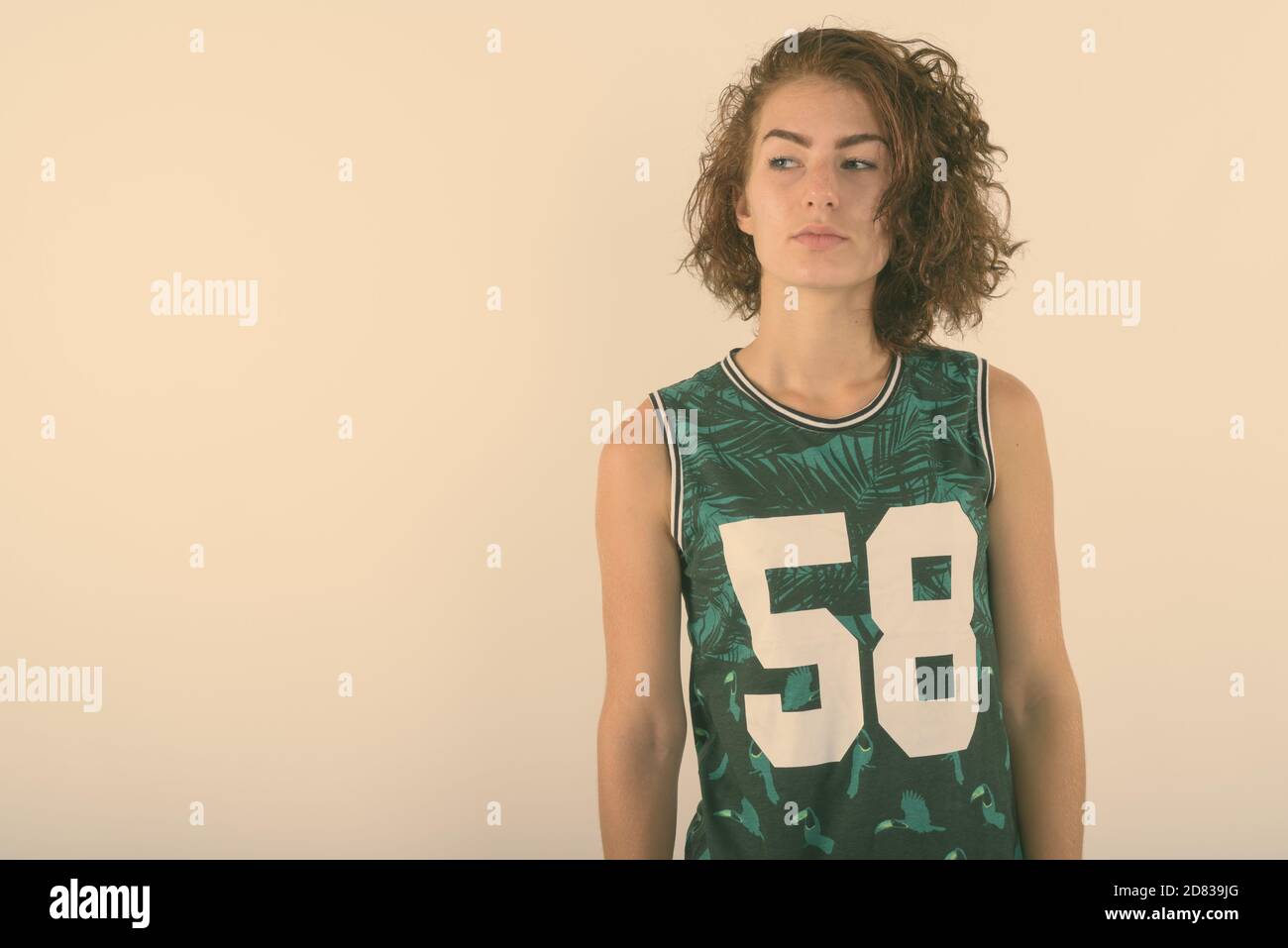 Studio shot of beautiful teenage girl thinking against white background ...