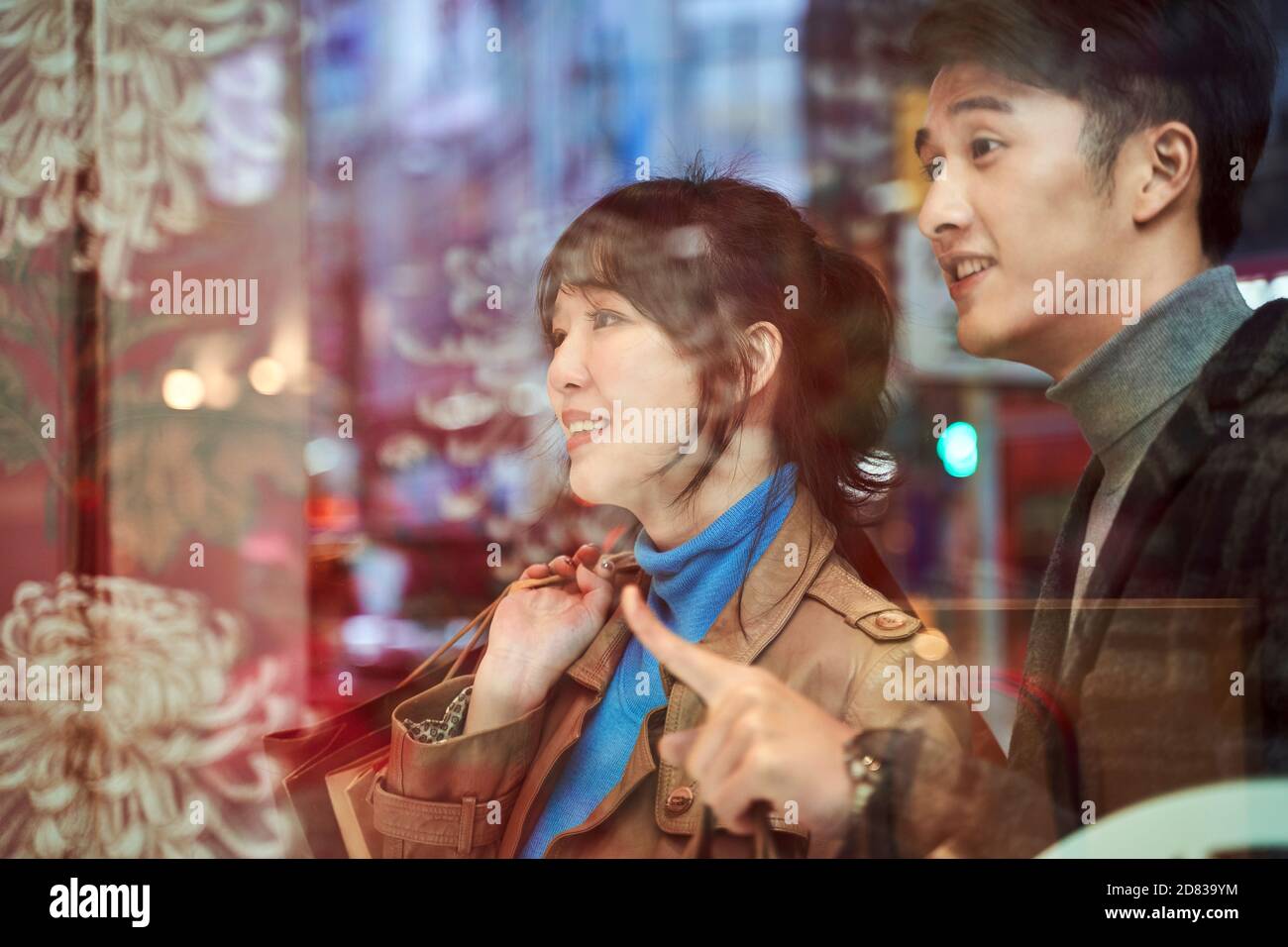 happy young asian couple looking into shop window in modern city Stock ...