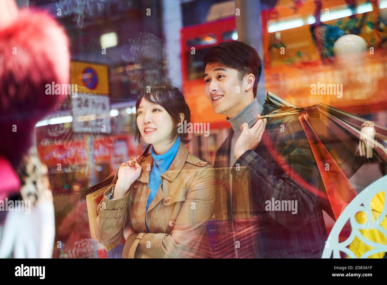 happy young asian couple looking into shop window in modern city Stock ...