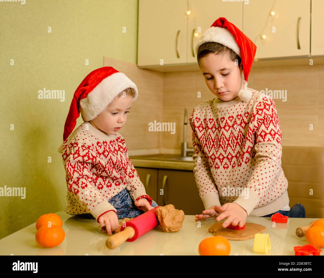 Happy kids making cookie for Santa in warm kitchen. Santa chefs Stock ...