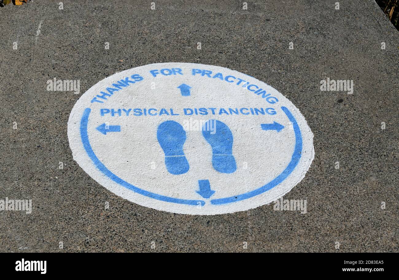 Physical distancing sign on cement ground hi-res stock photography and ...