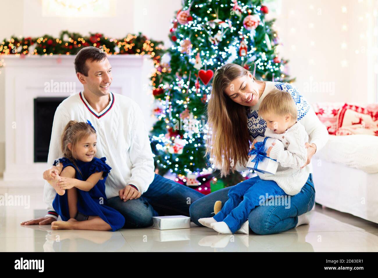 Family celebrating Christmas. Parents and kids decorate Xmas tree and ...