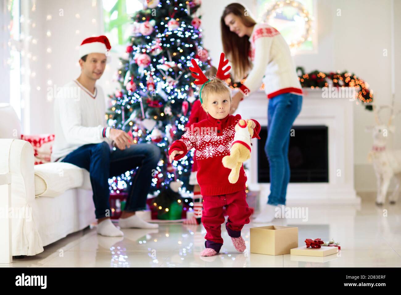 Family celebrating Christmas. Parents and kids decorate Xmas tree and ...