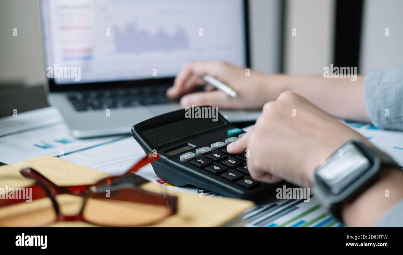 accountant working on desk using calculator for calculate finance ...
