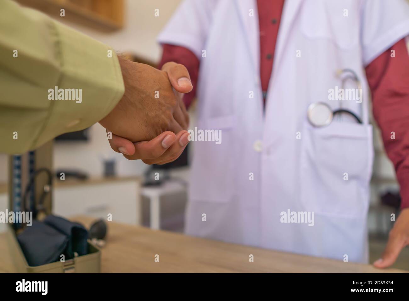 The patient shake hands the doctor to express his gratitude to the ...