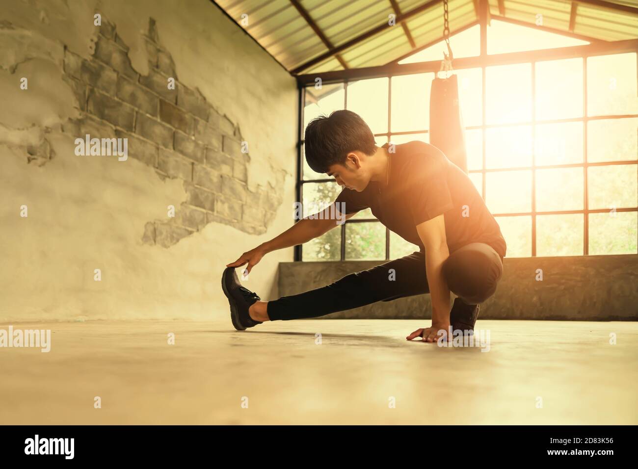 Man stretching out muscles in gym before exercise Stock Photo - Alamy