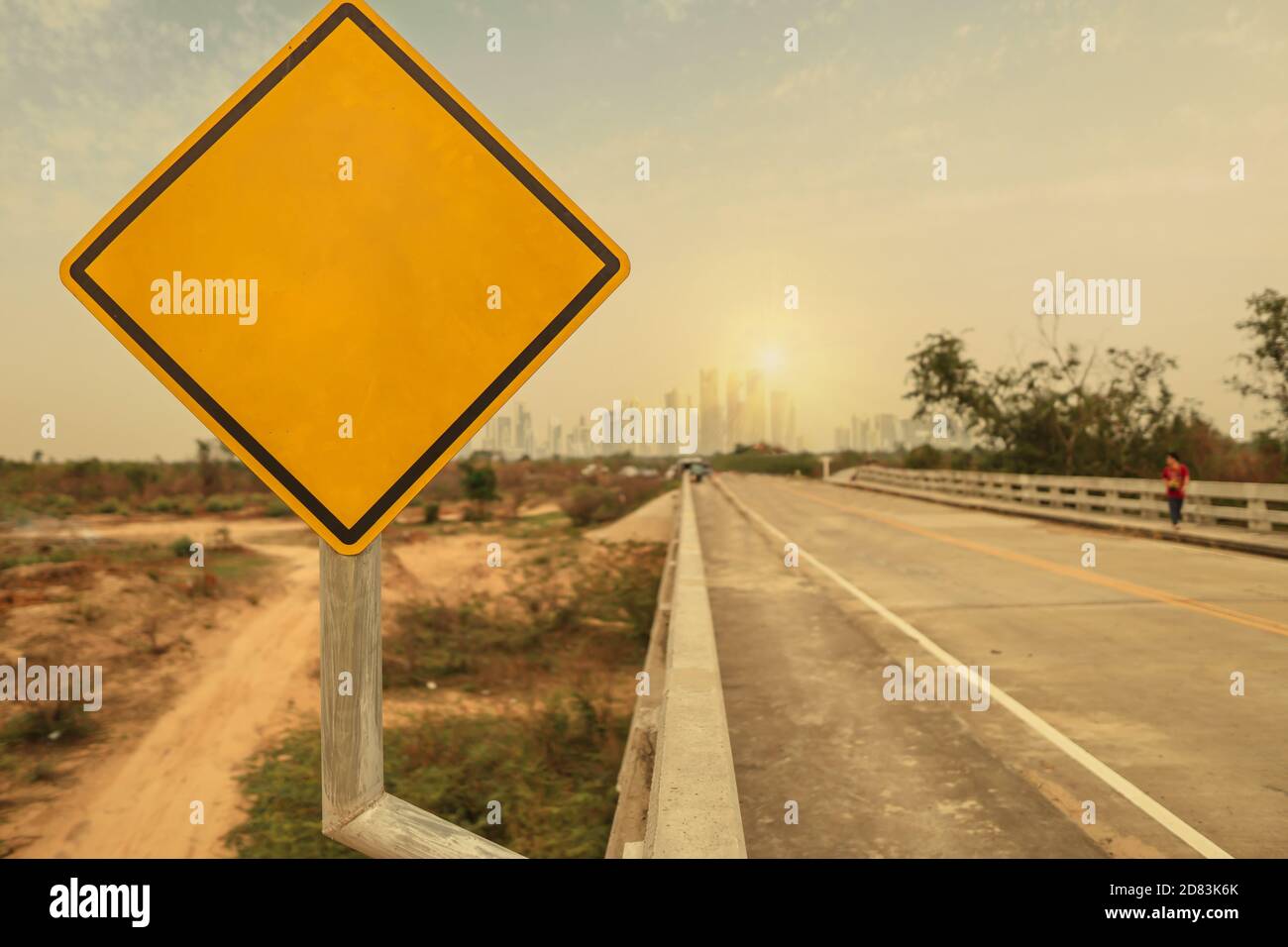 Empty yellow traffic sign on blur traffic road with city background ...