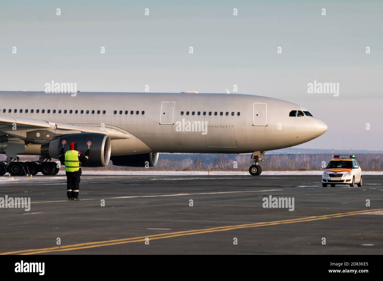 Passenger airplane is moving behind the follow me car. Airport ground ...