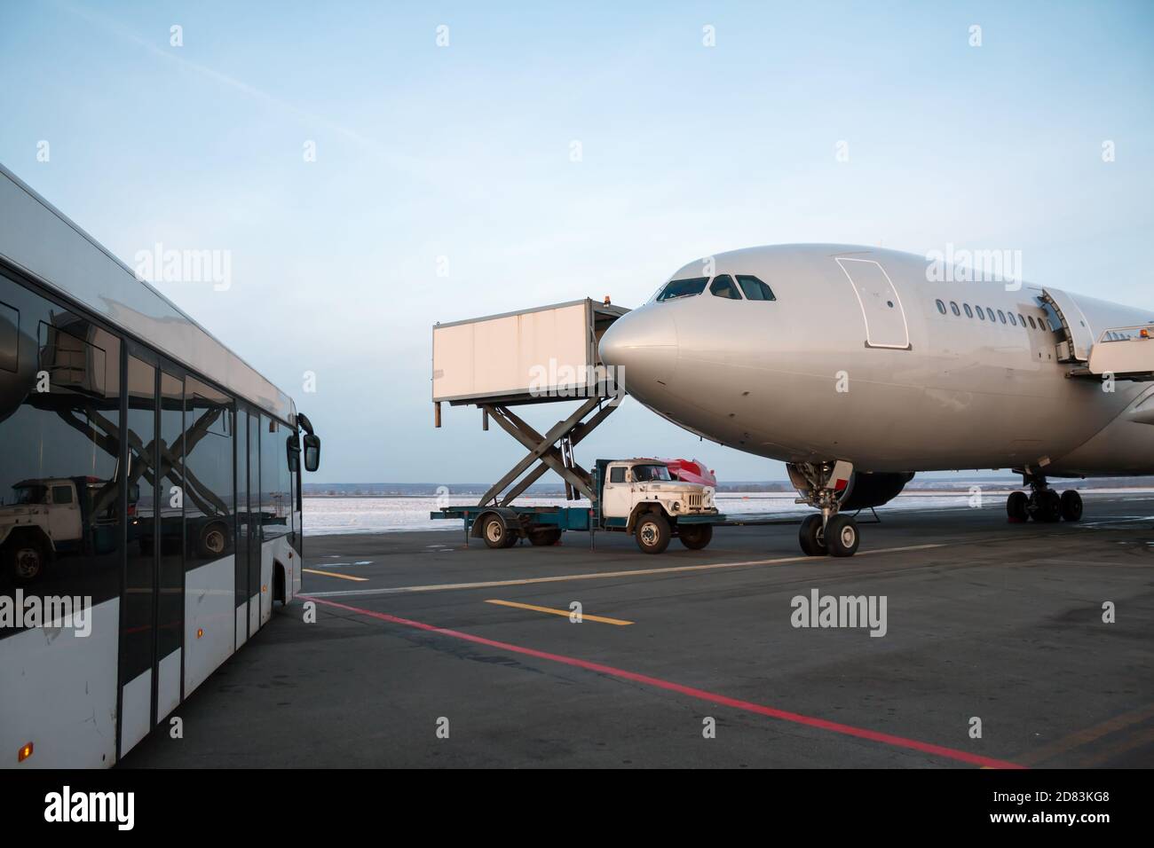Airport bus near the passenger airplane on which the catering truck ...