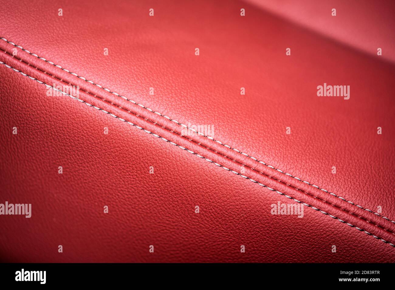 close-up red perforated leather car seat. Skin texture. Close-up corner ...