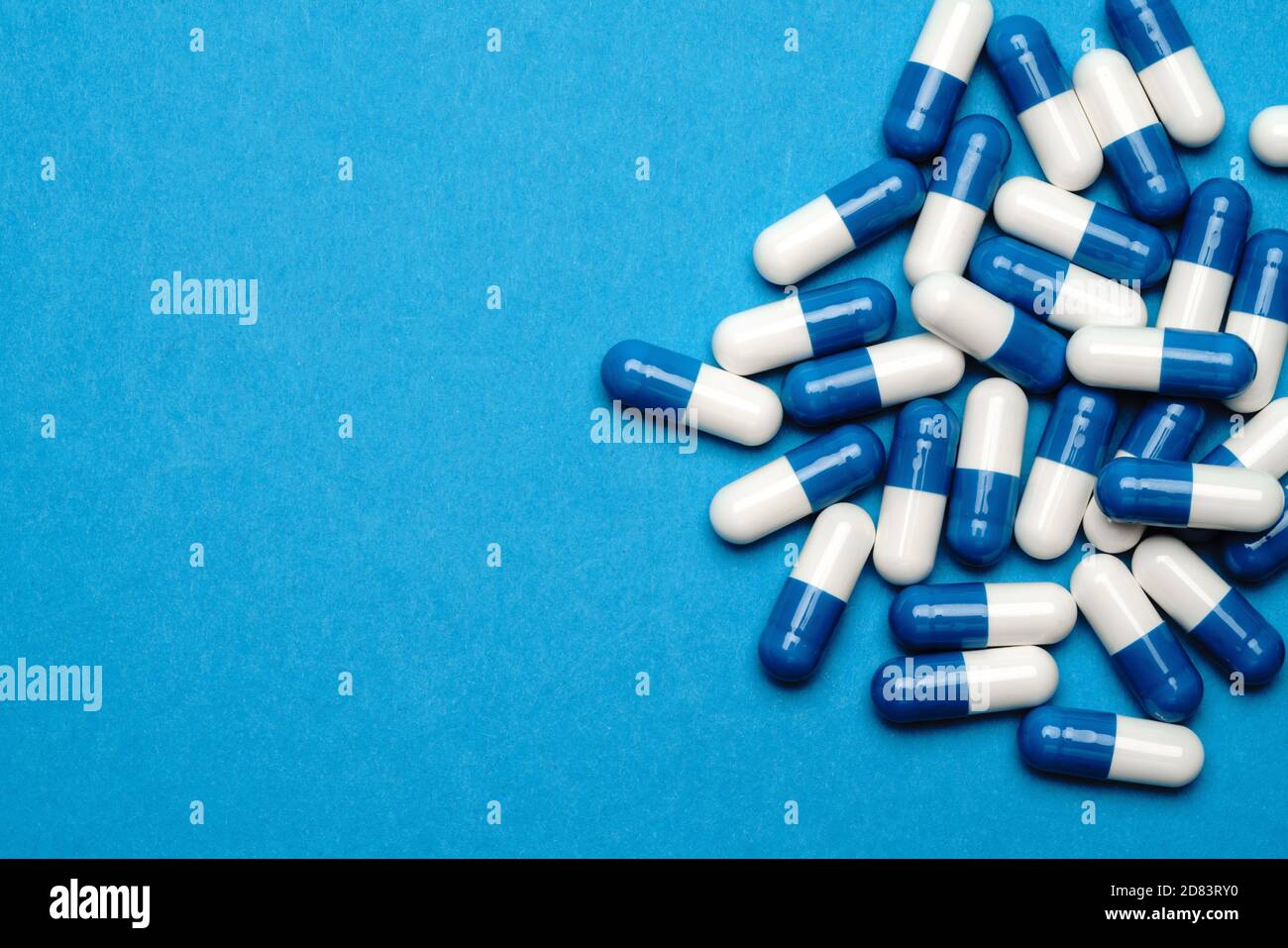 group of pills or capsules on blue background Stock Photo - Alamy