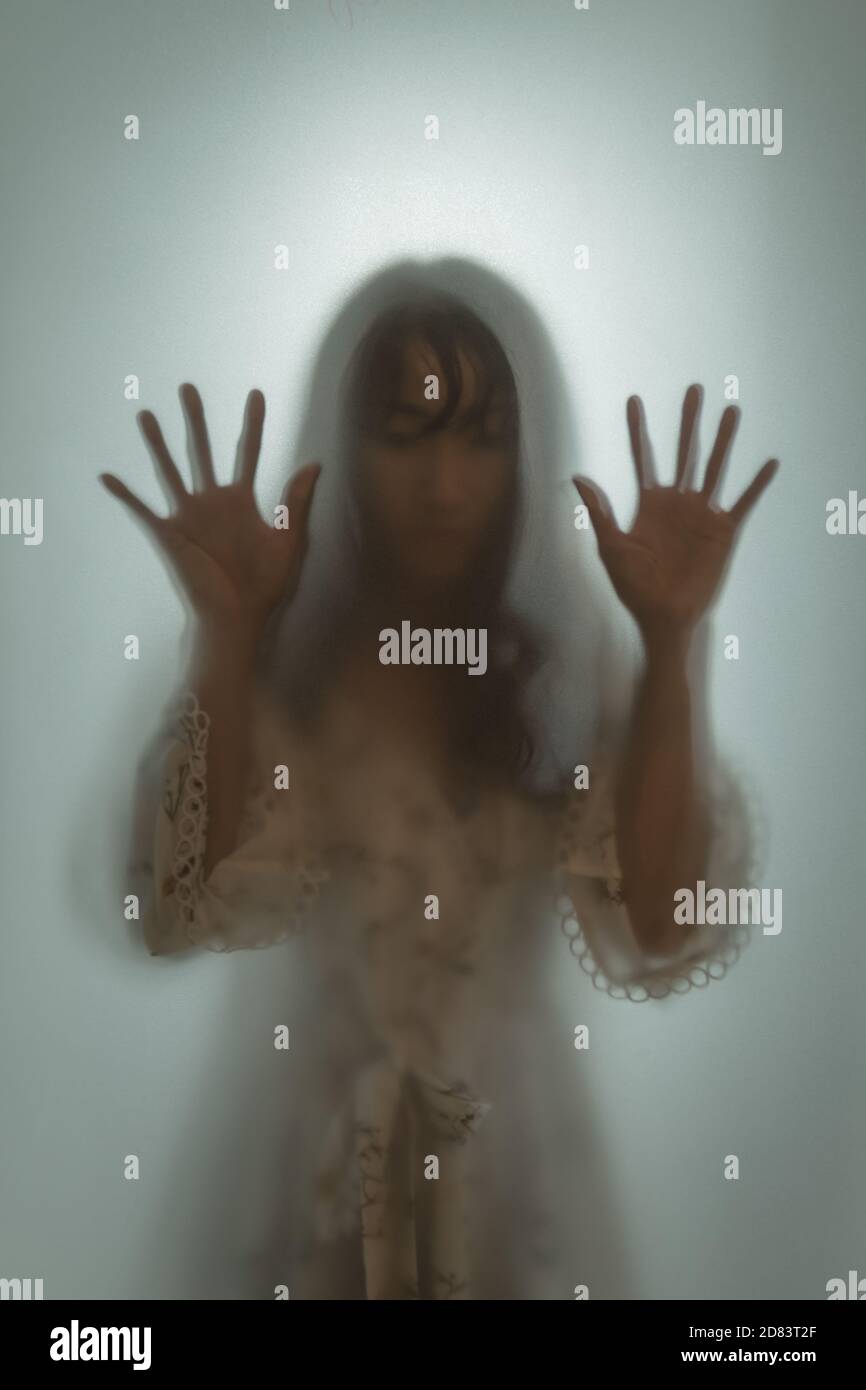 Ghost concept shadow of a women behind the matte glass blurry hand and ...