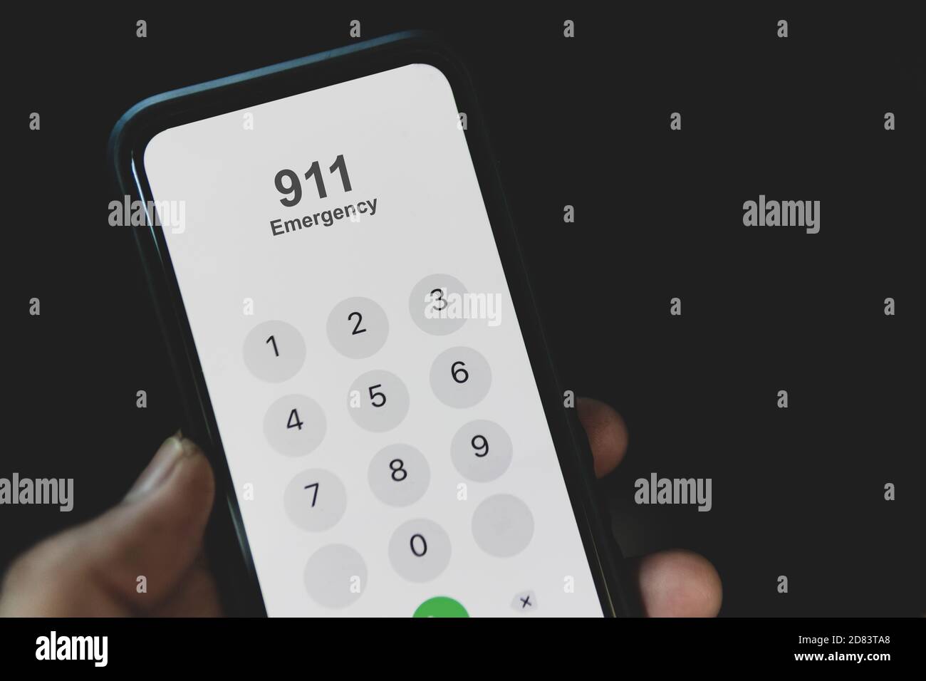 Hand holding cell phone with emergency number 911 on black background Stock Photo - Alamy
