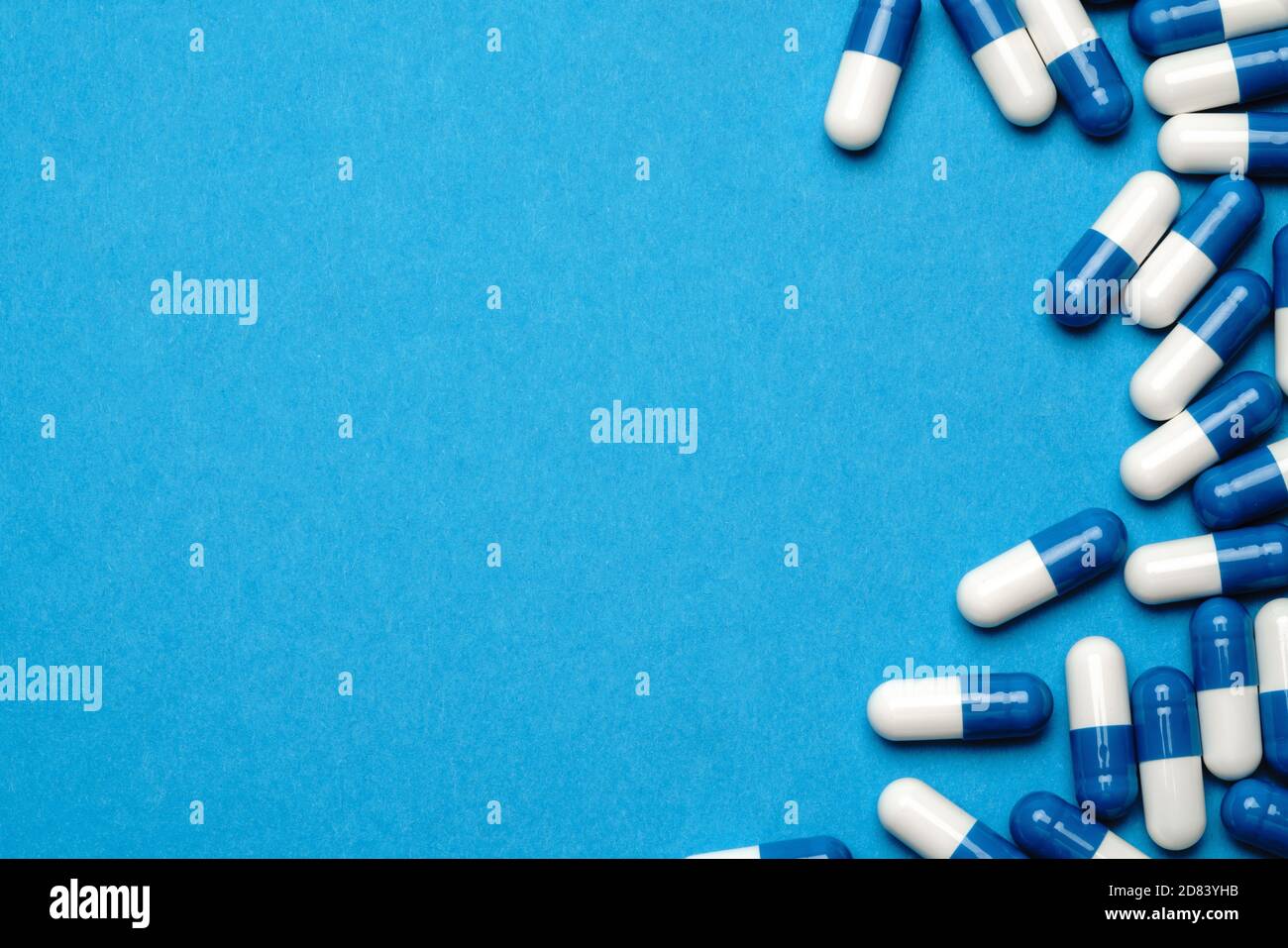 group of pills or capsules on blue background Stock Photo - Alamy