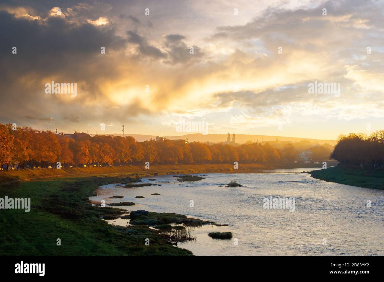 river uzh at sunrise. beautiful cityscape autumn scenery. linden alley ...