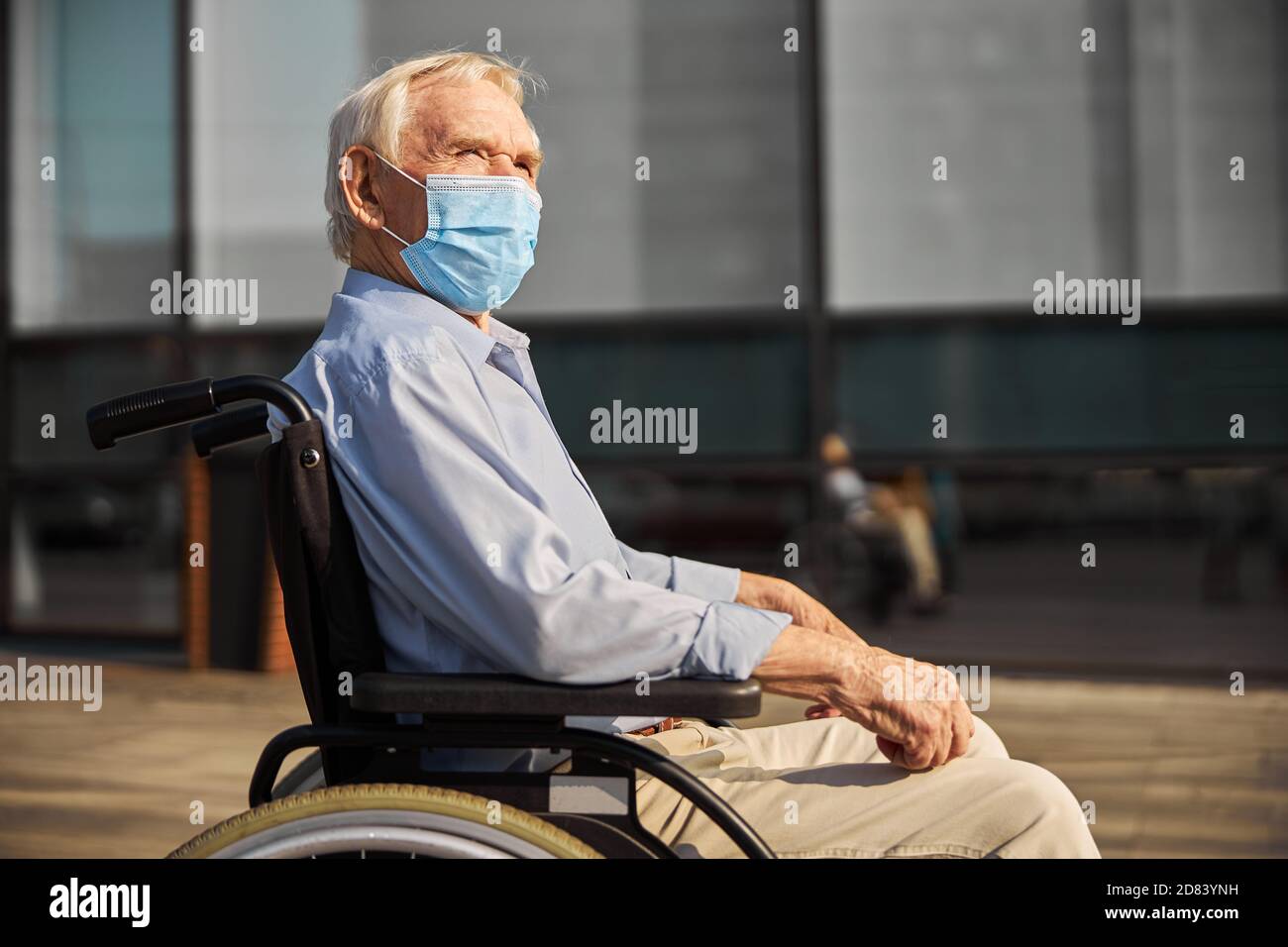 Old handicapped man in wheelchair with hands on armrests Stock Photo ...